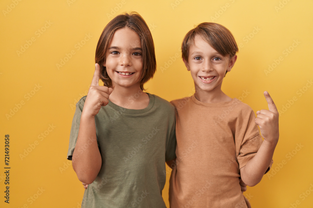 Two adorable boys standing together, happily hugging. one kid, finger ...