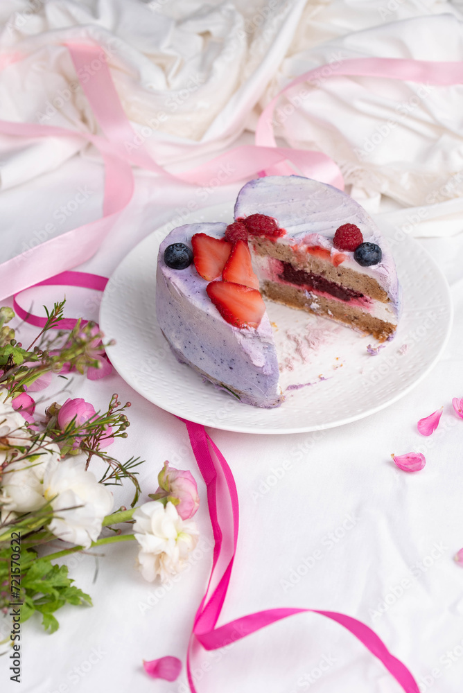 Trendy bento cake in love heart shape form on a light breakfast in bed ...