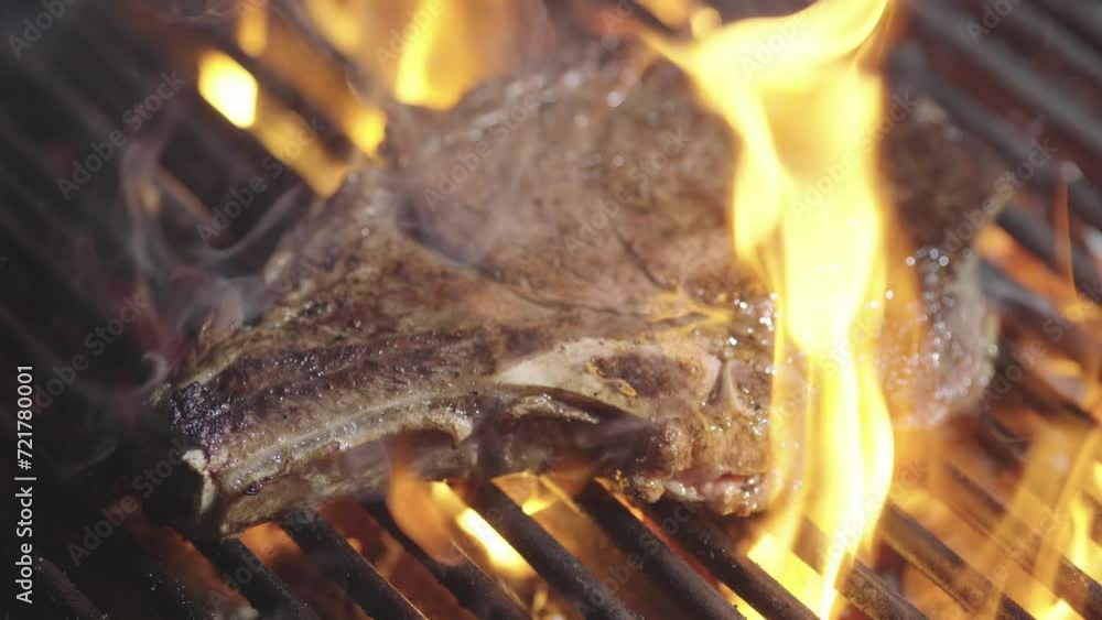 Roast beef. Beef steak on grill with flames. Rib-eye steaks cooking on ...