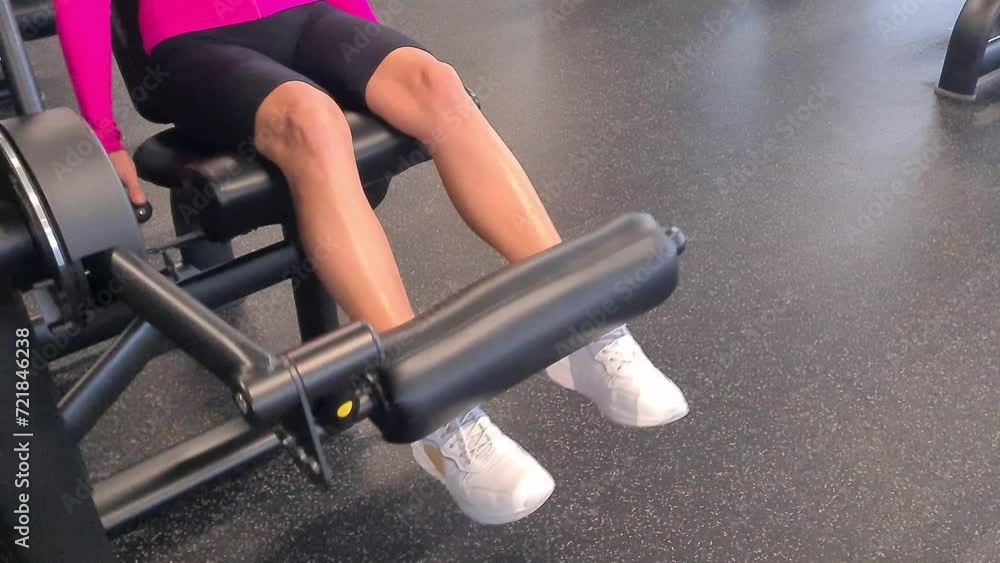 Female legs during training of quadriceps muscles of thigh at strength ...
