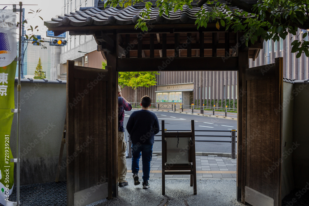 Tokyo, Japan, 1 November 2023: Man entering a traditional Japanese gate on a quiet street. Stock ...