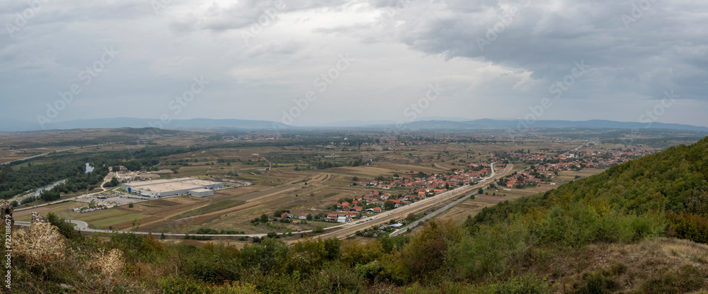 A landscape photograph of a storm that hangs over the industrial part ...