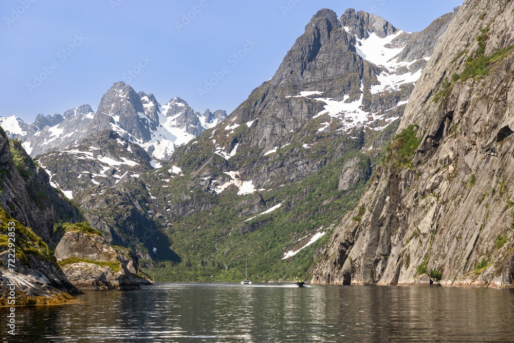 A catamaran cruises through Trollfjorden in Lofoten, Norway, amidst ...