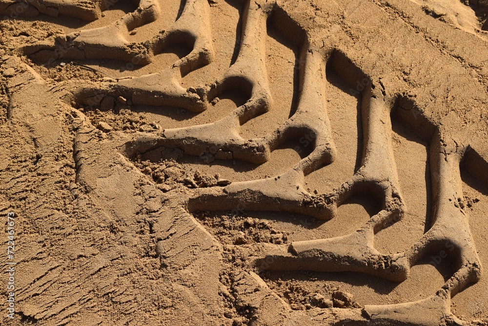 Wheel tracks in the wet sand close up. wheel tread mark on a dirt road ...