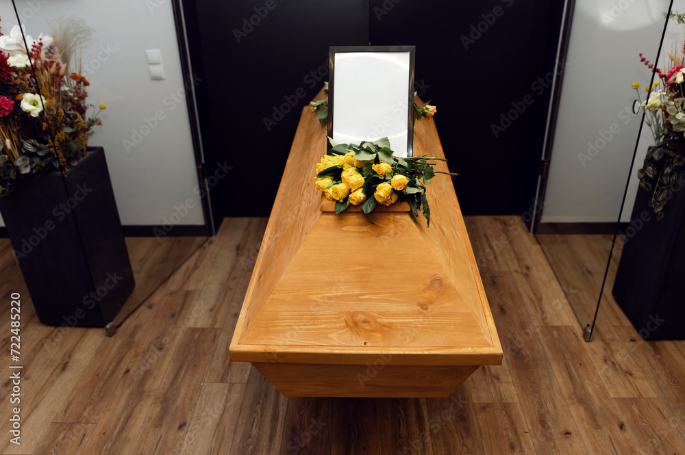 funeral concept. flowers on the coffin and an empty photo frame ...