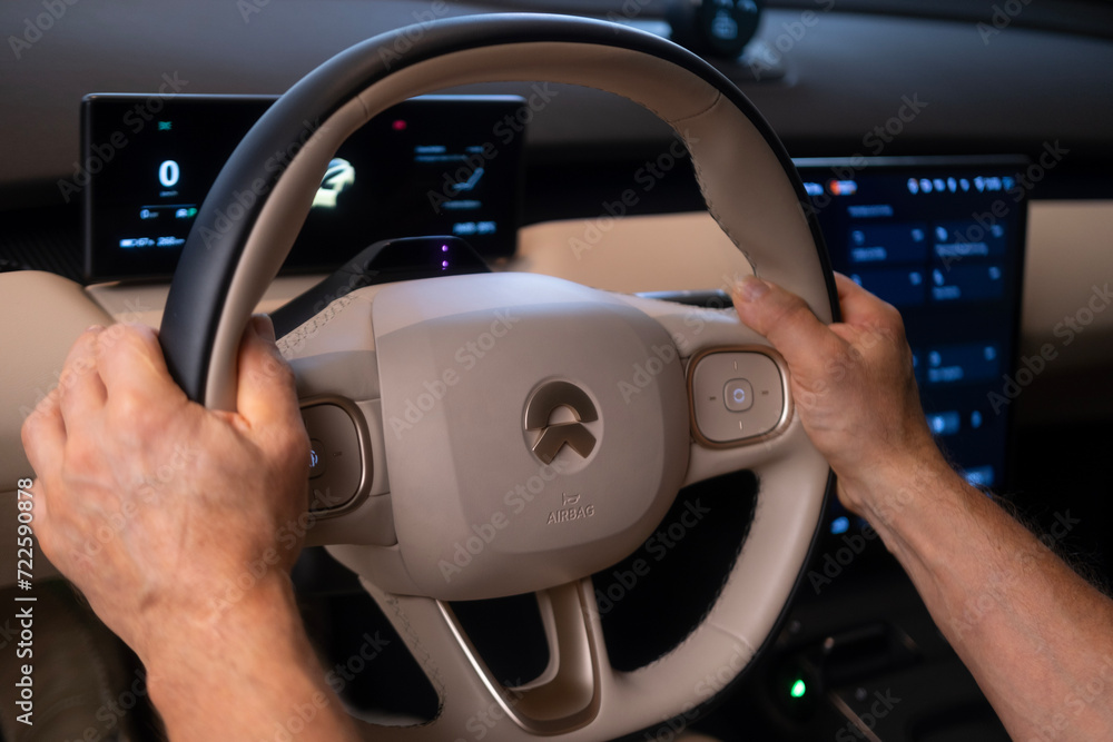 Behind steering wheel of Nio electric car, male hands on Driver's ...