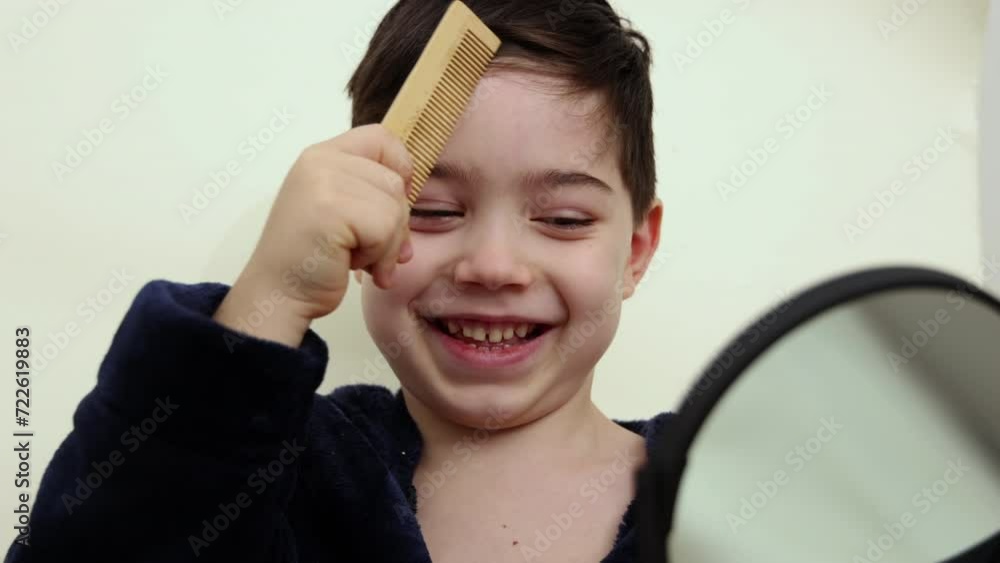 smiling adorable kid using wooden comb to brush his hair.smiling child ...