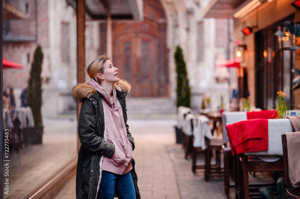 Relaxed Walk by City Café, Young woman enjoying a leisurely walk by an ...