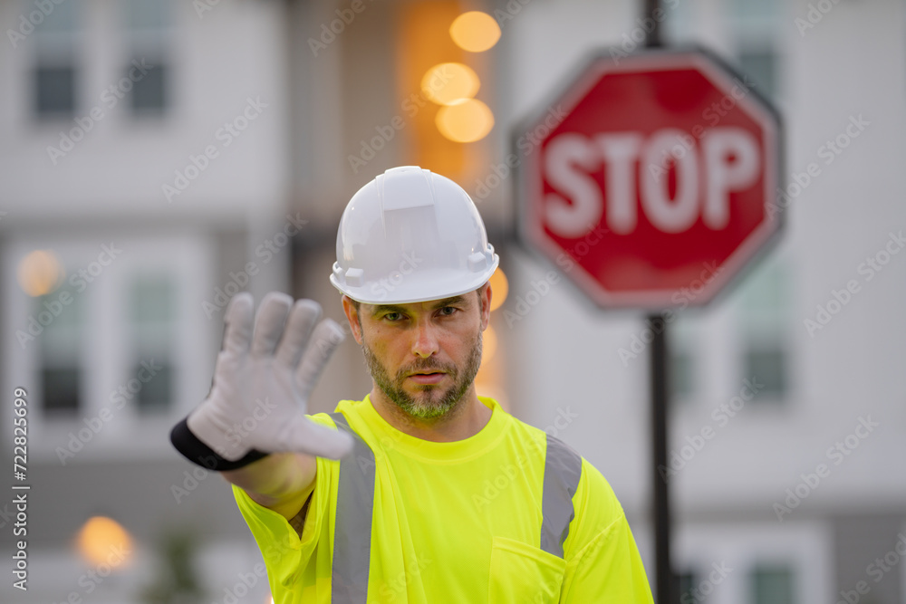 Serious engineer with stop road sign. Builder with stop gesture, no ...