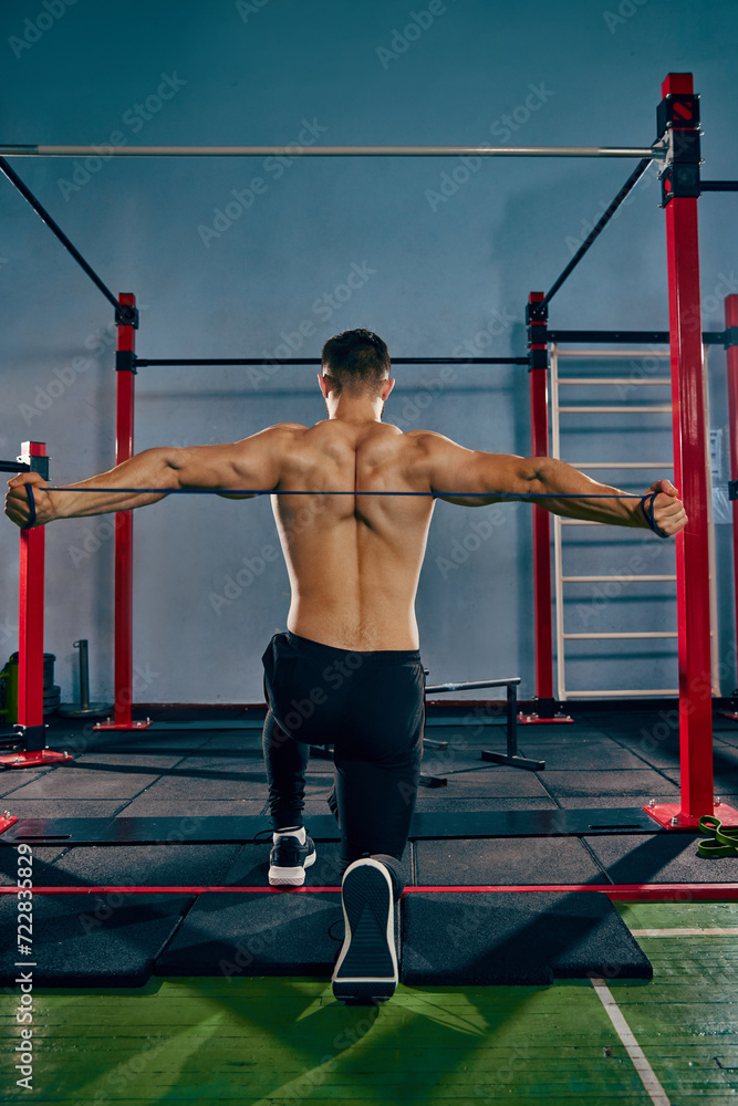 Back training. Athletic, sportive young man training shirtless in gym ...