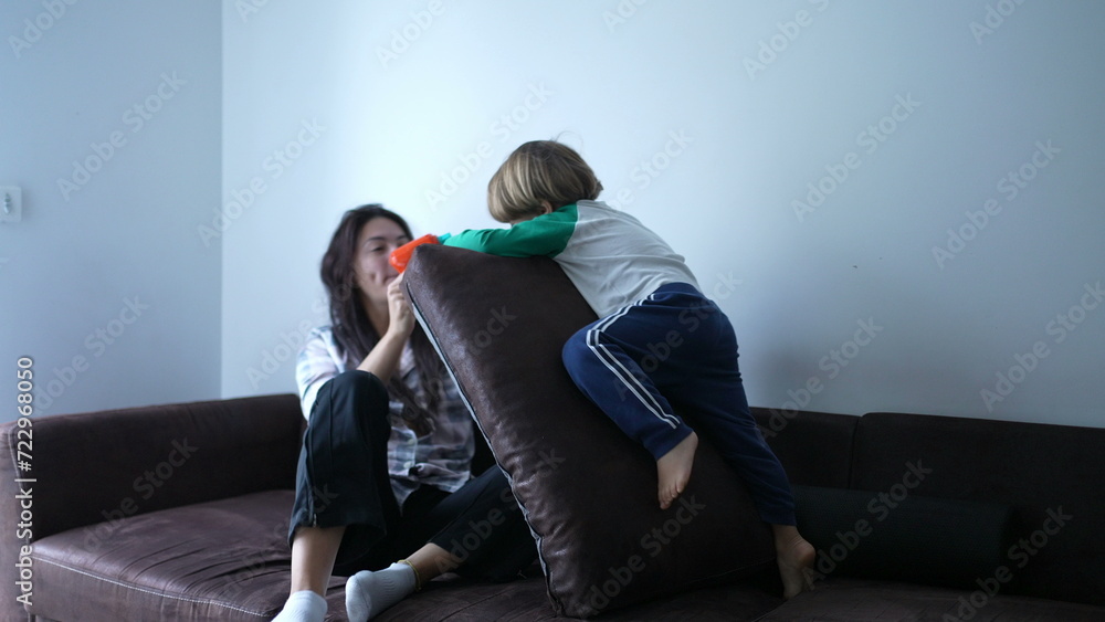 Child and mother playing together at home sofa couch pretending to ...