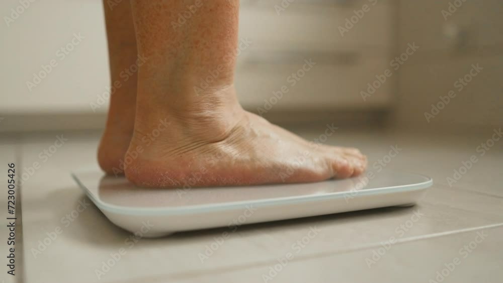 Male on weight scale on floor background, 60s senior woman steps on ...