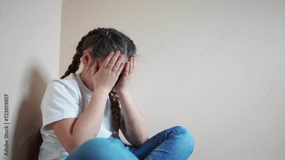 sad girl sitting in the corner lifestyle crying a covered her face with ...