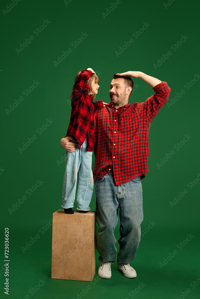 Father and child in matching red plaid shirts mirroring each other's ...