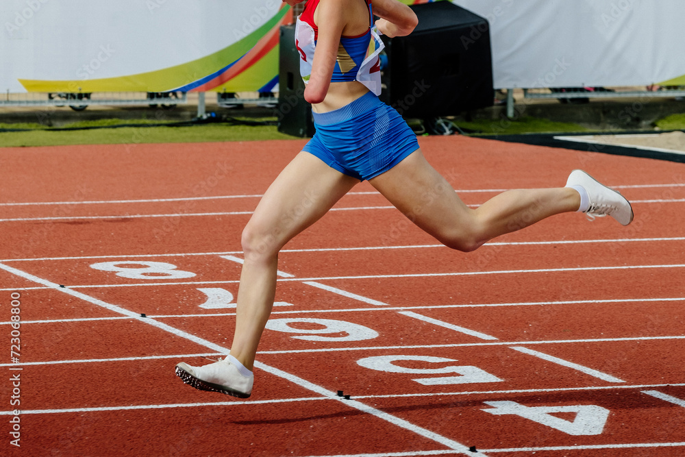 female runner para-athlete on limb deficiency running finish line track ...