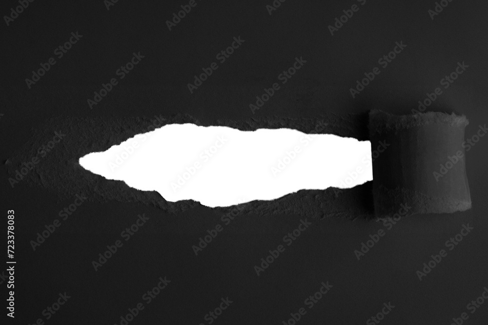 Black thick paper, torn in the middle with an empty hole. And an empty ...