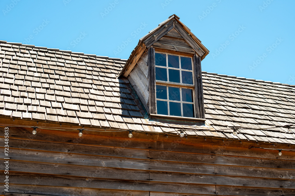An old dormer window with multiple panes of glass, white trim and a ...
