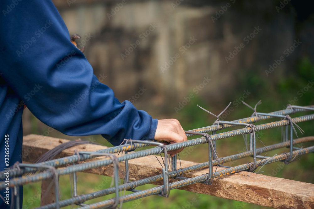 Men hands using pincer pliers iron wire reinforcement of concrete work ...