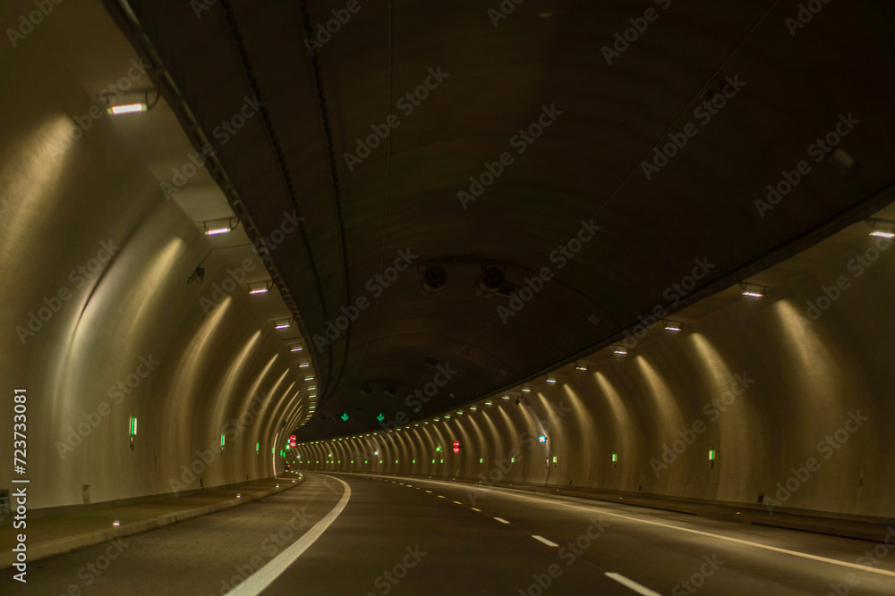 Underground city road tunnel, curve night illuminated freeway with car ...