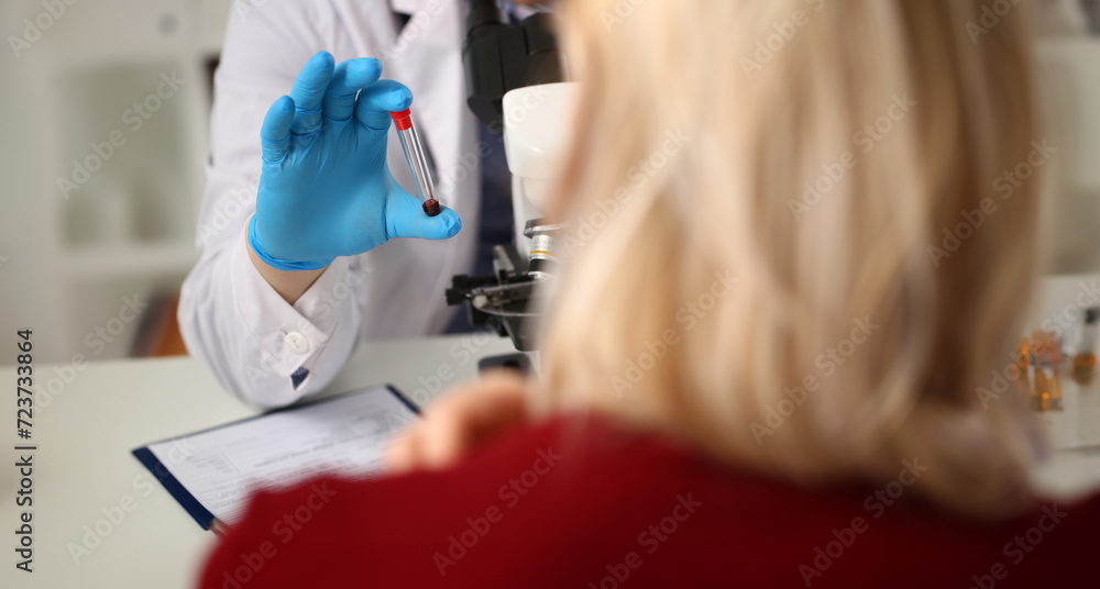 Doctor holds analyzed blood sample front patient. Laboratory studies ...