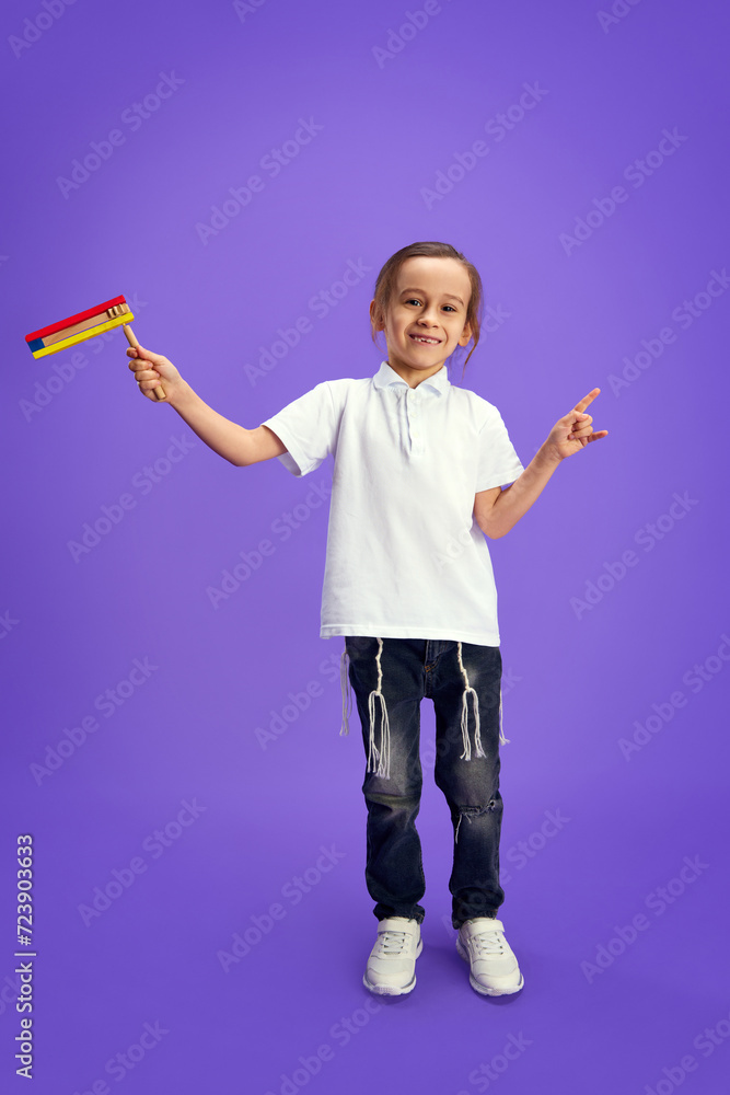 Little Jewish boy, kid playing with grogger against purple studio ...