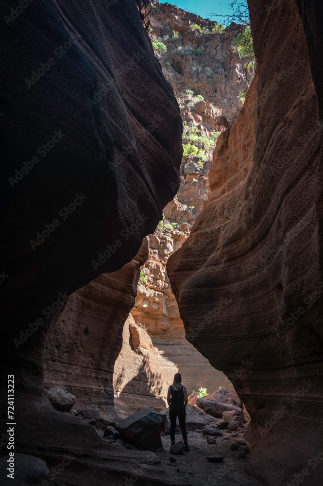 Canyon formed by ravine between walls of eroded stone formations ...