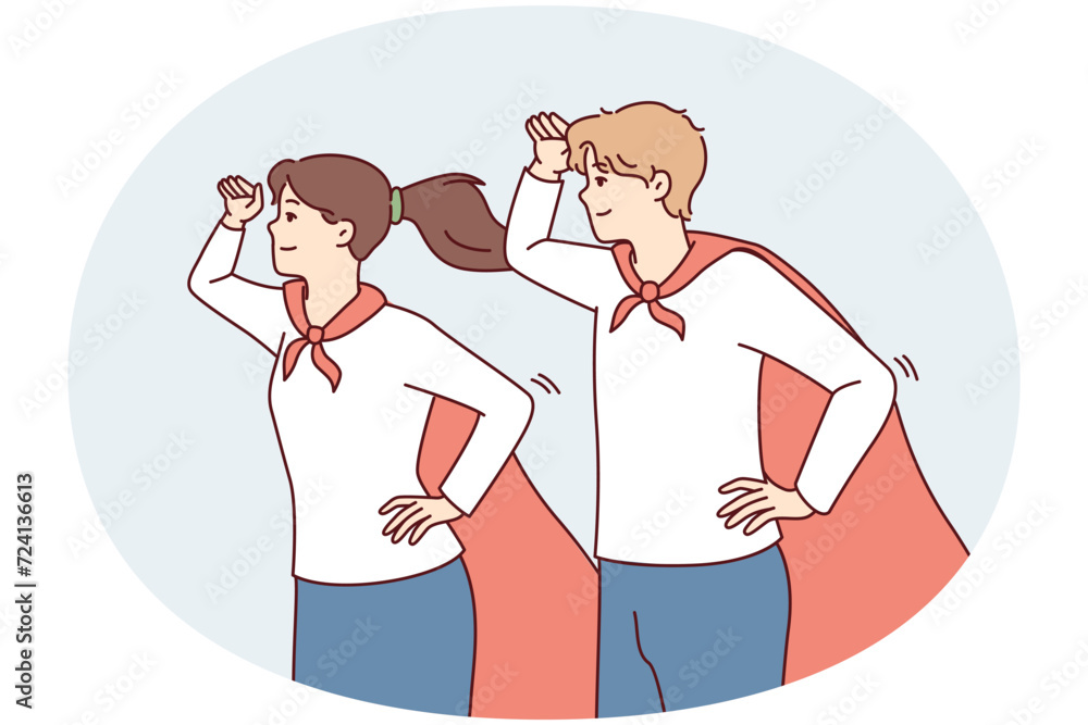 Guy and girl in superhero capes look into distance with their hands to ...