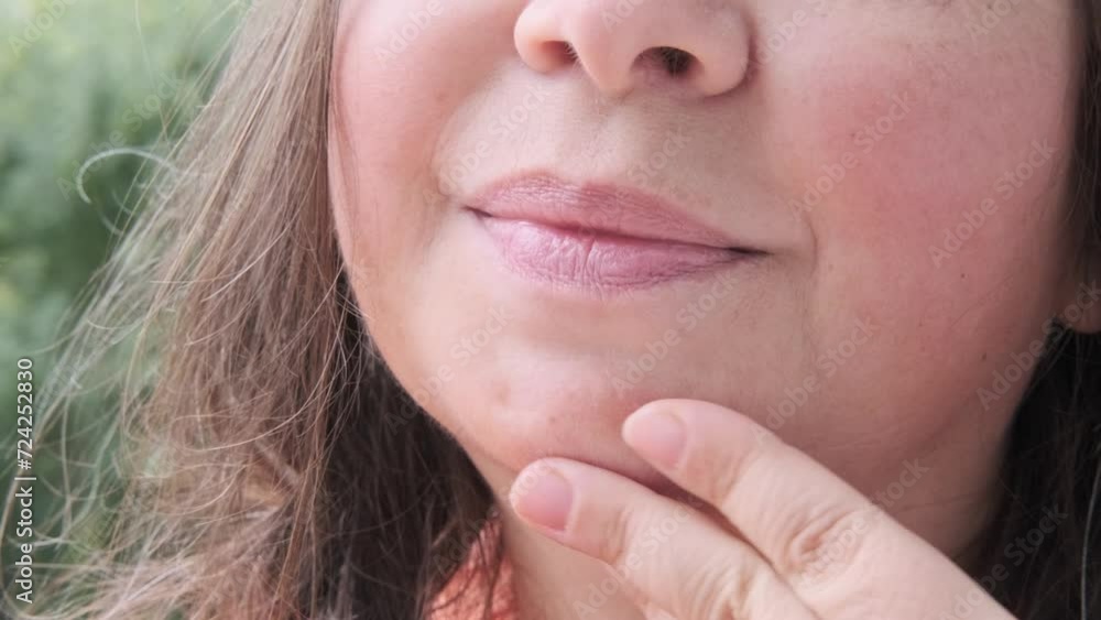close up of mature female face, woman 50 years old carefully examines ...