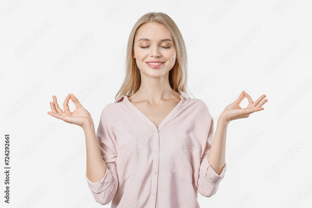 Beautiful female keeping eyes closed while practicing yoga indoors ...