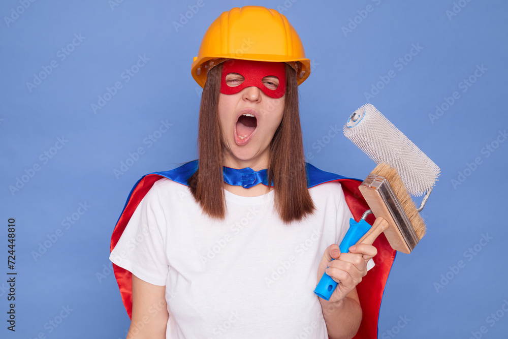 Sleepy overworked woman painter wearing superhero costume and ...