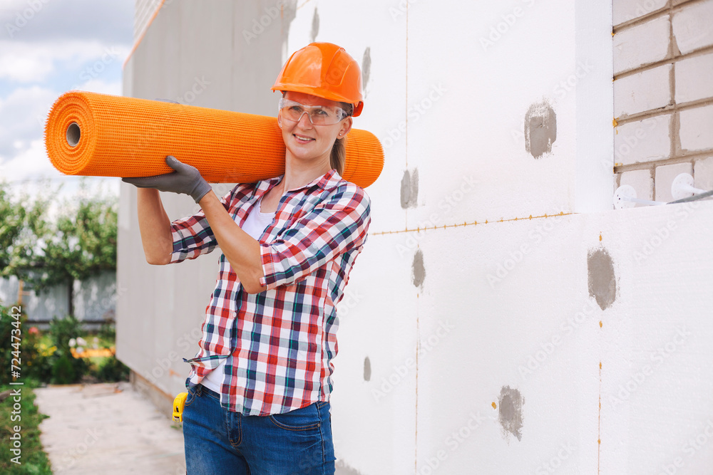 The woman with rolls of reinforcing fiberglass. Insulation of the house ...