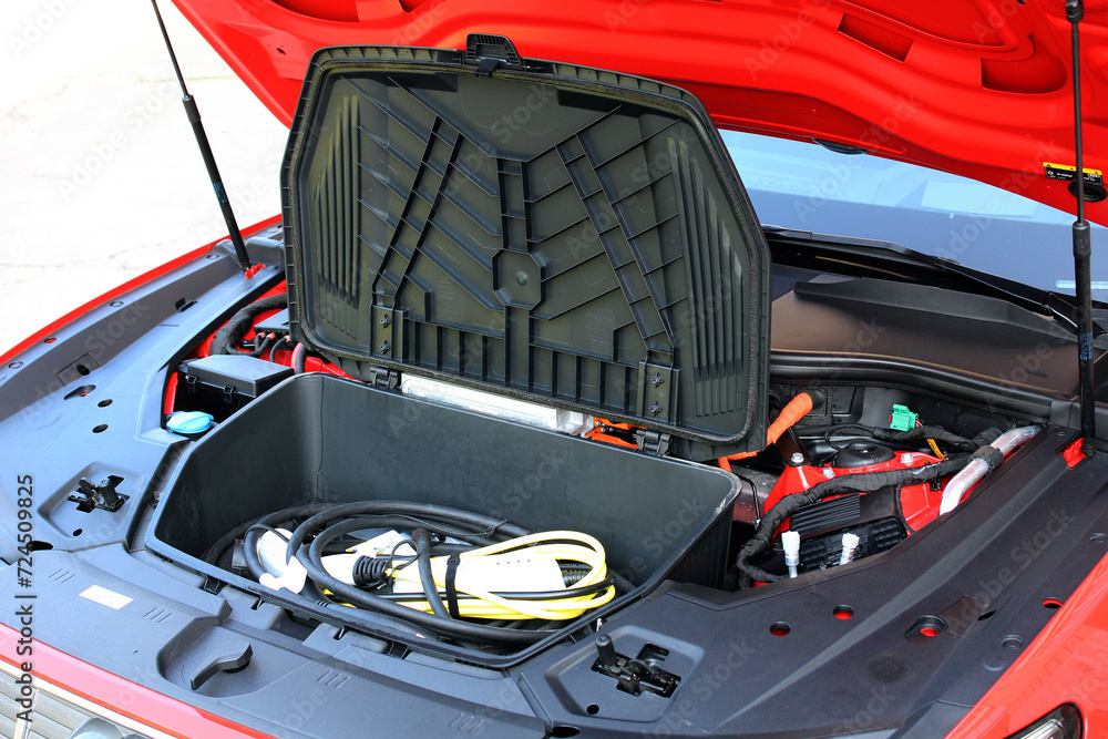 Electric car open hood. Electric vehicle charger storage location under ...