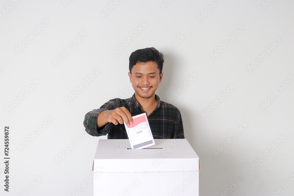 Portrait of excited Asian man inserting and putting the voting paper ...