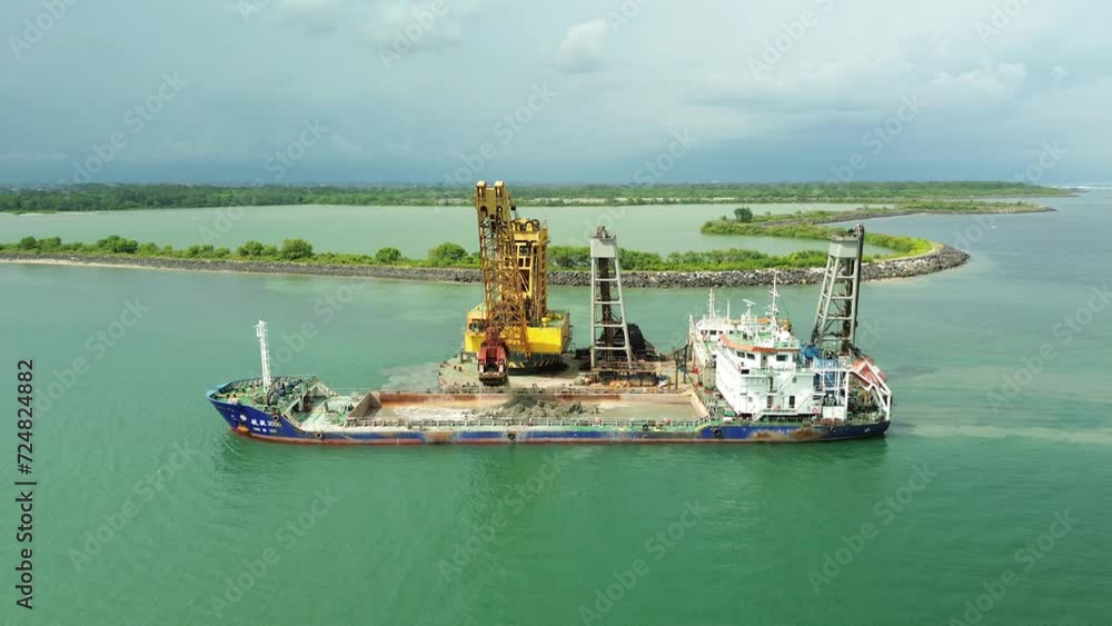 Aerial view of a crane on a floating platform extracting sand from the ...