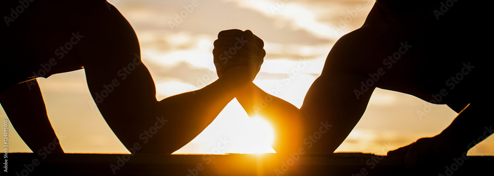 Rivalry, closeup of male arm wrestling. Sunset, sunrise. Men measuring ...