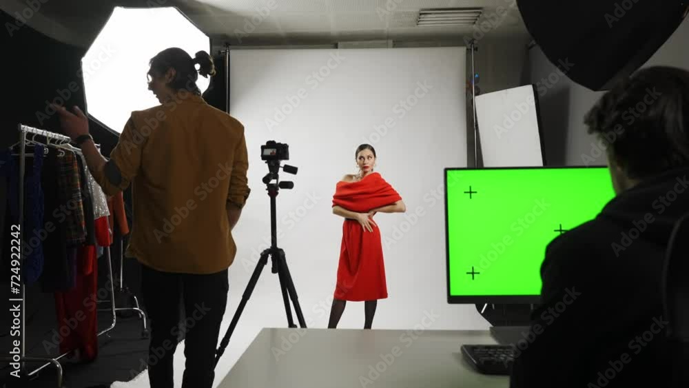 Model and production team in the studio. Female poses for photographer ...
