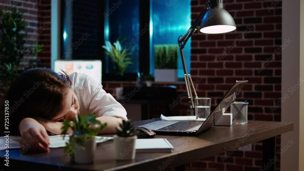 Sleepy employee asleep on computer desk late at night in brick wall ...