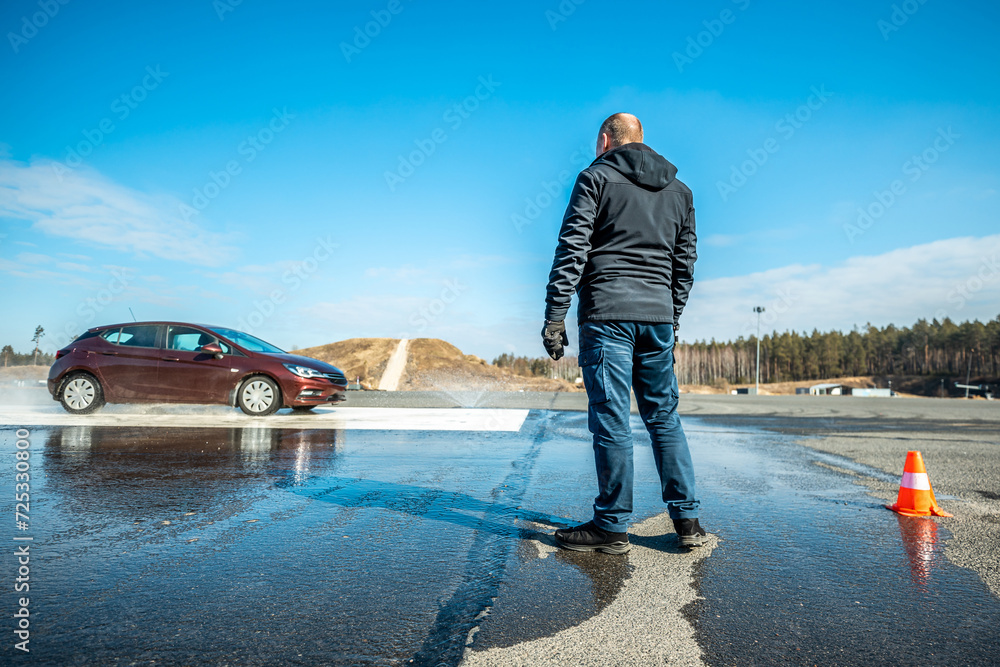 dynamic car braking test on wet road surface with water splashes and ...