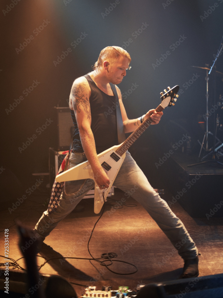 Music festival, man and playing guitar on stage, night and artist with ...