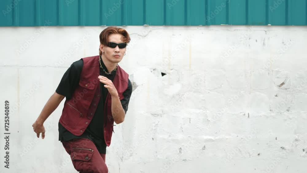 Handsome street dancer practicing break dancing at white back ground ...