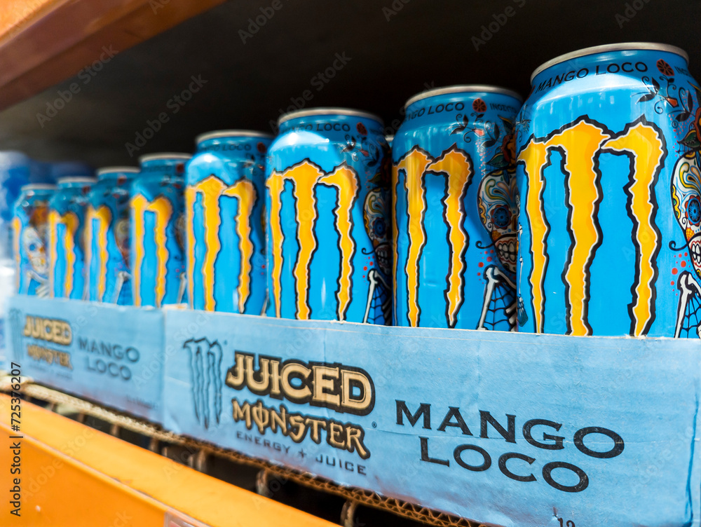 Brightly colored cans of Mango Loco Juiced Monster energy drink aligned ...