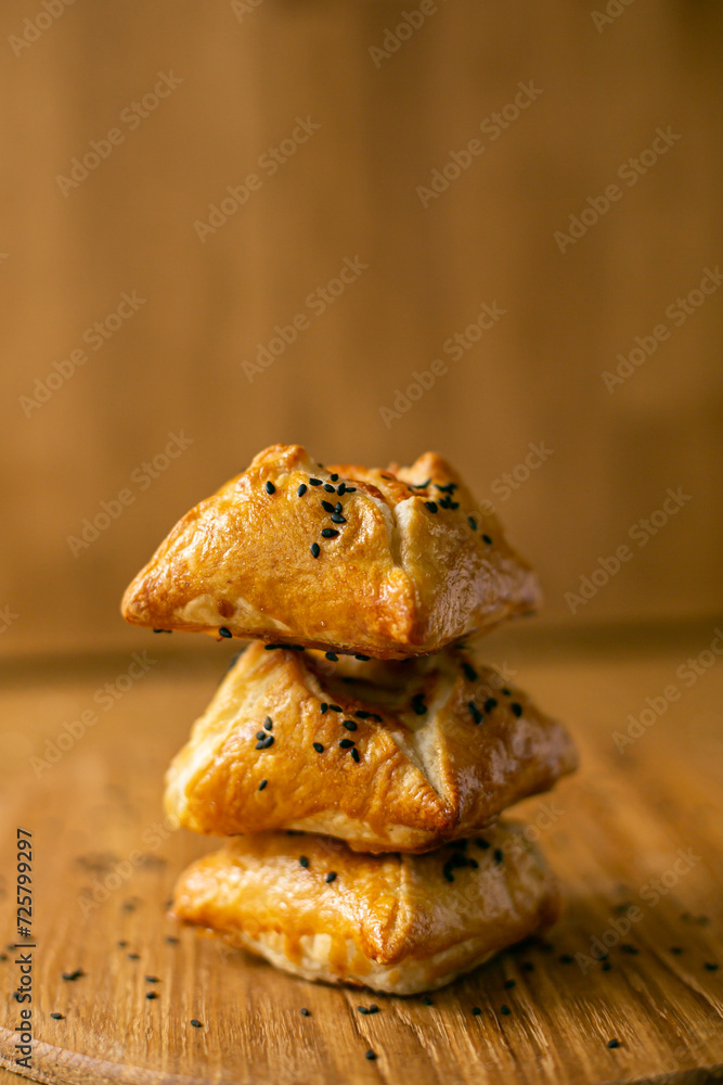four edible square puff pastry baskets with chiken on a white round ...