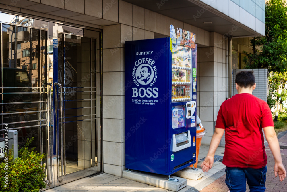 Tokyo, Japan, 28 October 2023: Man walking past a vending machine ...