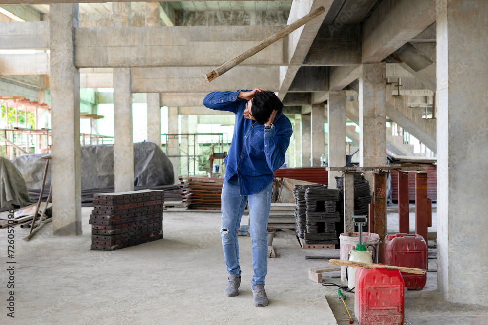 a man construction worker with no safety gear walking in a new building ...