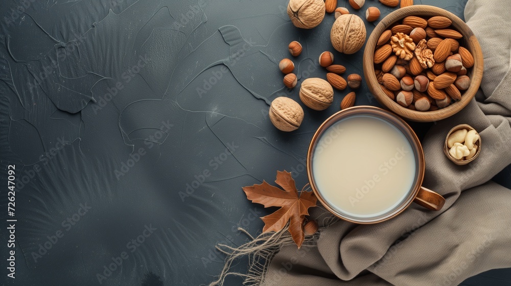 Banner with nut milk in a mug and nuts on a dark background. Top view ...