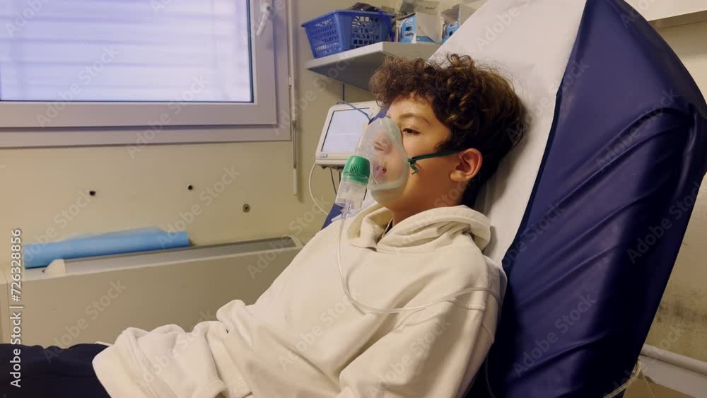 Sick teenager with an inhaler at hospital. An unhealthy child makes ...