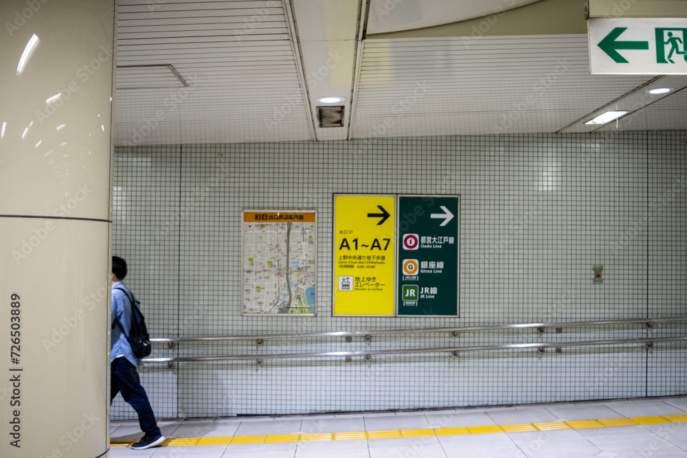 Tokyo, Japan, 30 October 2023: Man walking by directional signs in a ...