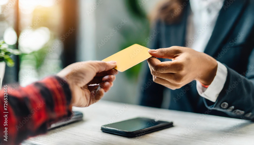 hands passing credit card from customer to receptionist, symbolizing ...