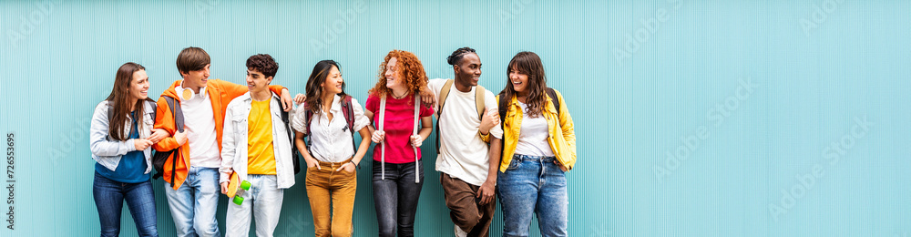 Diverse college students standing together on a blue wall - Photo ...