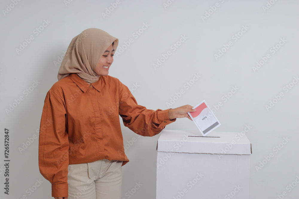 Portrait of Asian hijab woman inserting and putting the voting paper ...